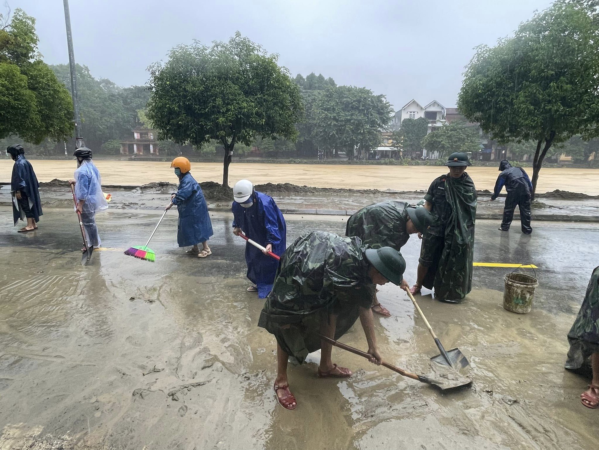 Bộ đội, thanh niên cùng giúp dân dọn bùn non sau mưa lũ