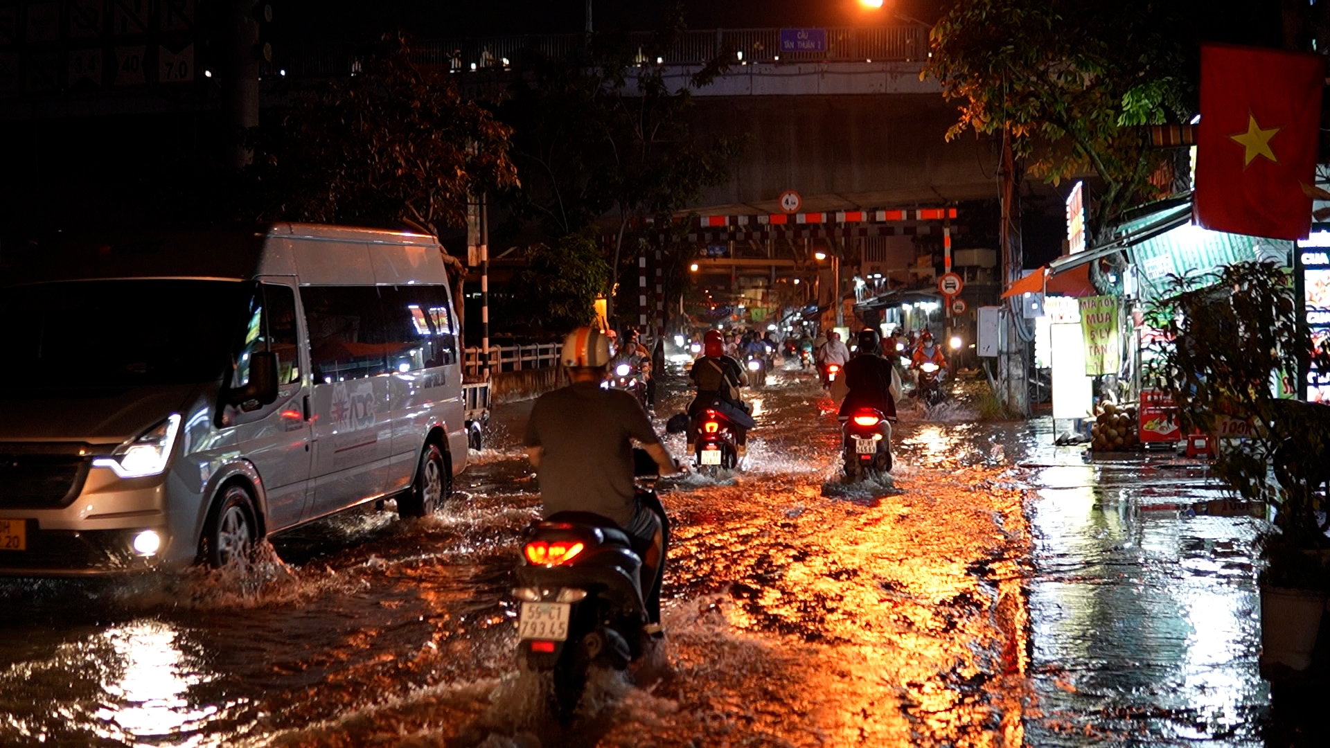 Triều cường ‘nuốt’ đường Trần Xuân Soạn, người dân TP.HCM bì bõm giờ tan tầm