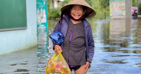 Mưa lũ miền Trung: Người dân vượt nước lũ đi mua nhu yếu phẩm